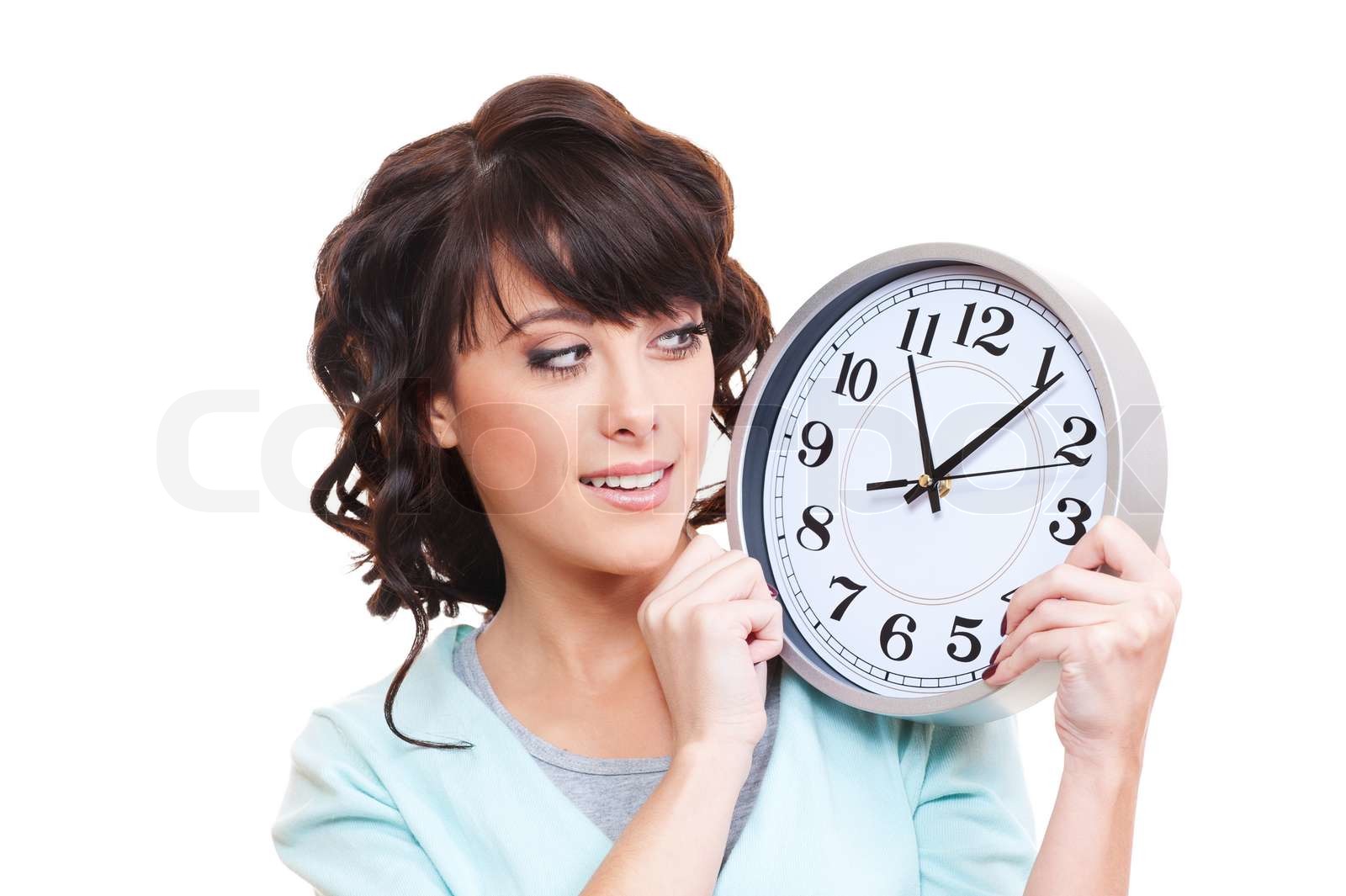 studio shot of smiley woman looking at clock | Stock image | Colourbox