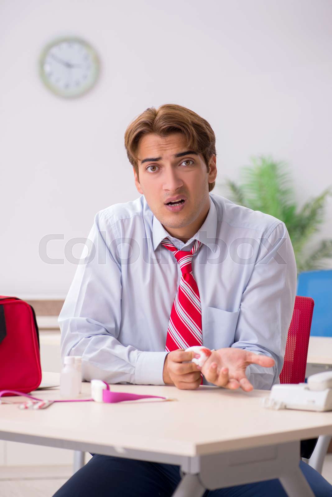 Man with first aid kit in the office | Stock image | Colourbox