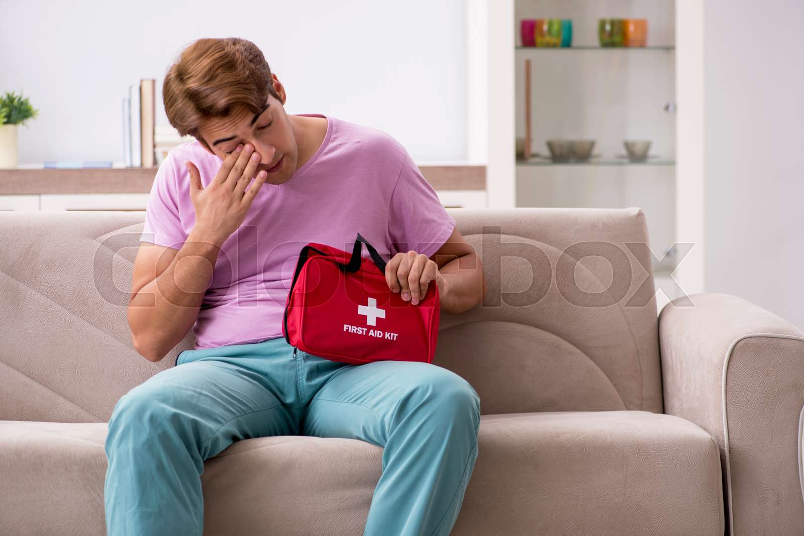 Sick man at home with first aid kit | Stock image | Colourbox