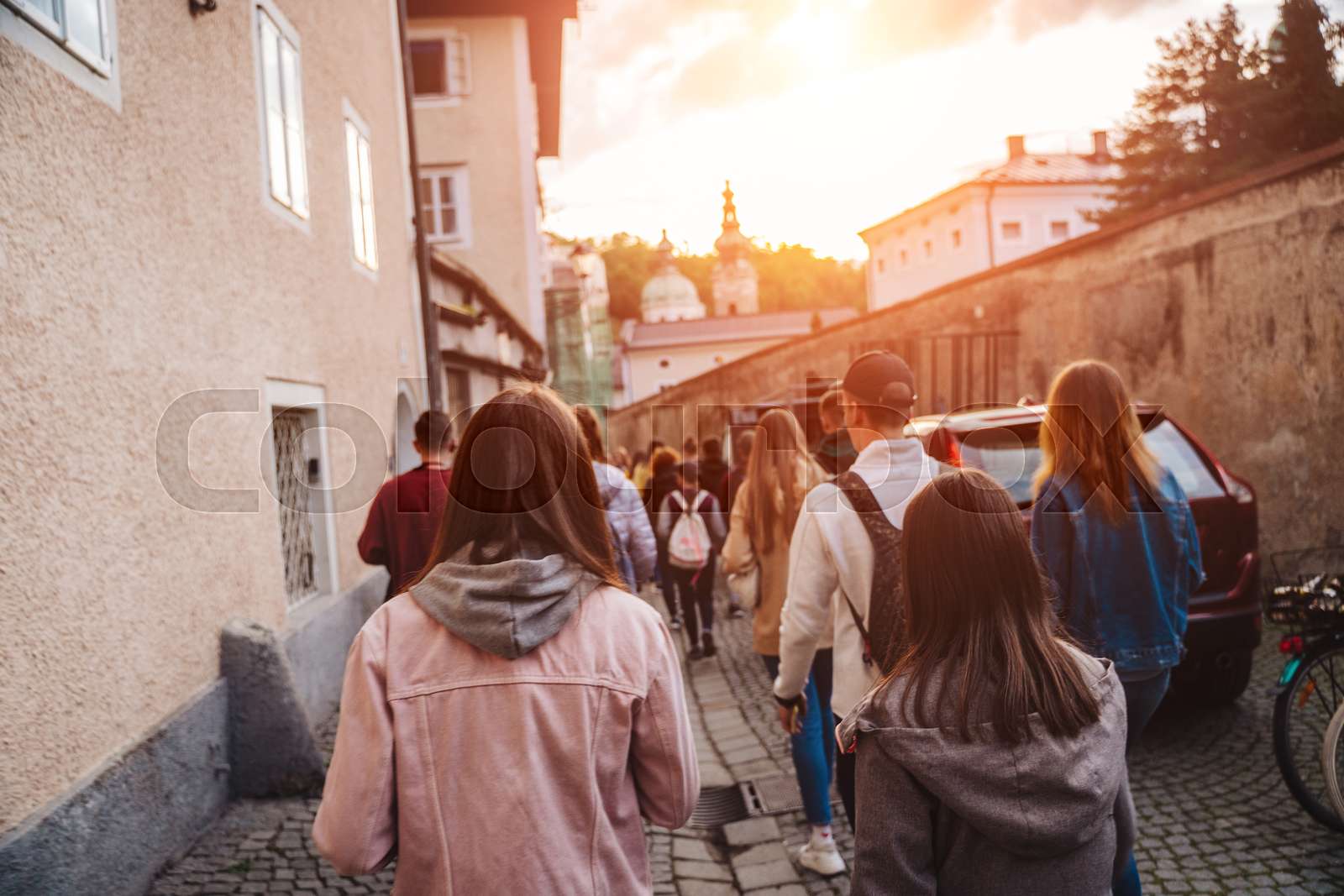 Rear view of people walking together, visiting old city street. | Stock ...
