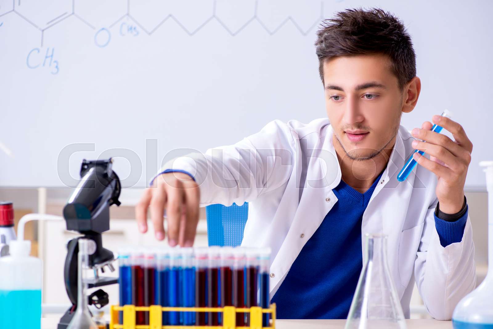 Young chemist sitting in the lab | Stock image | Colourbox