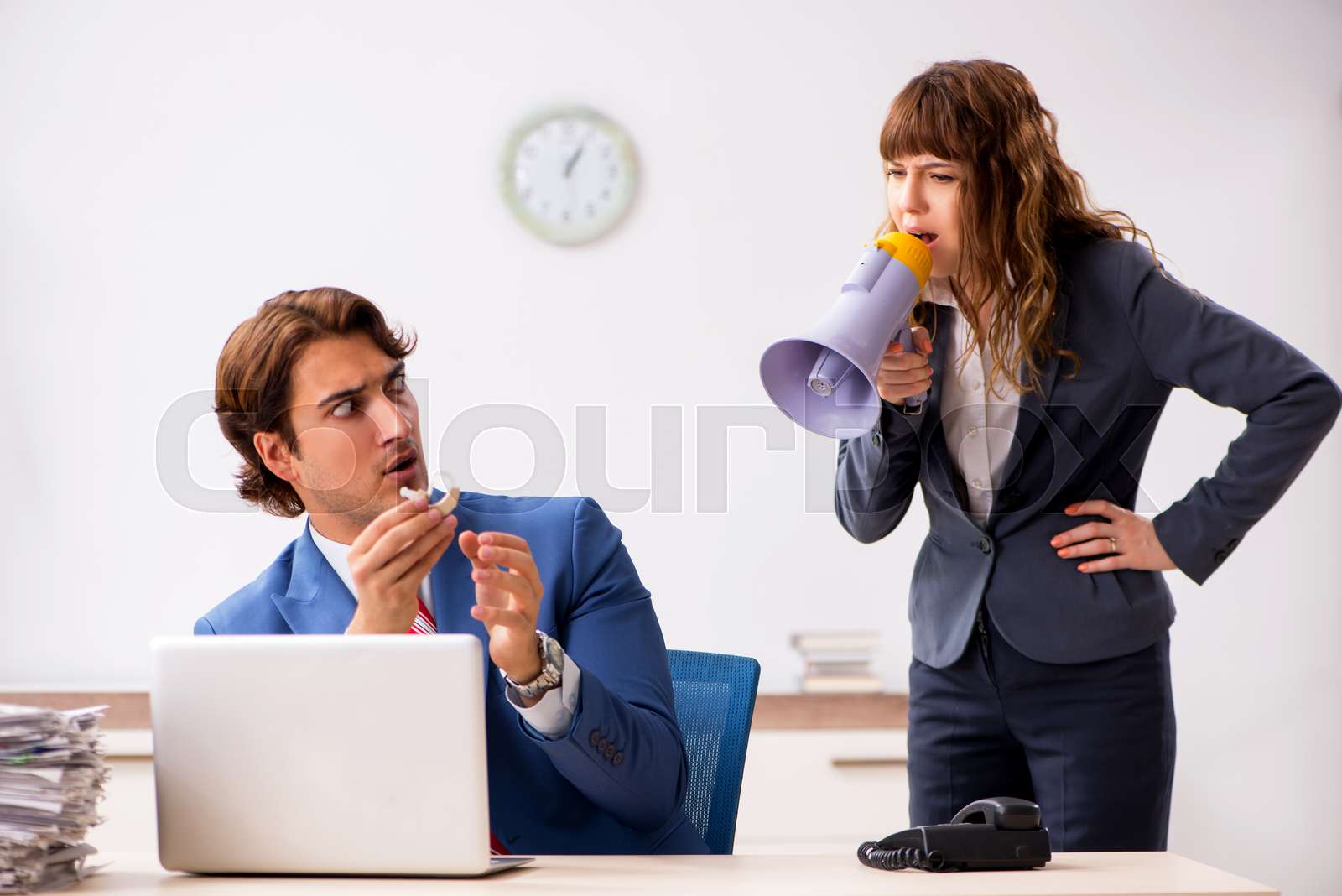 Deaf employee using hearing aid talking to boss | Stock image | Colourbox