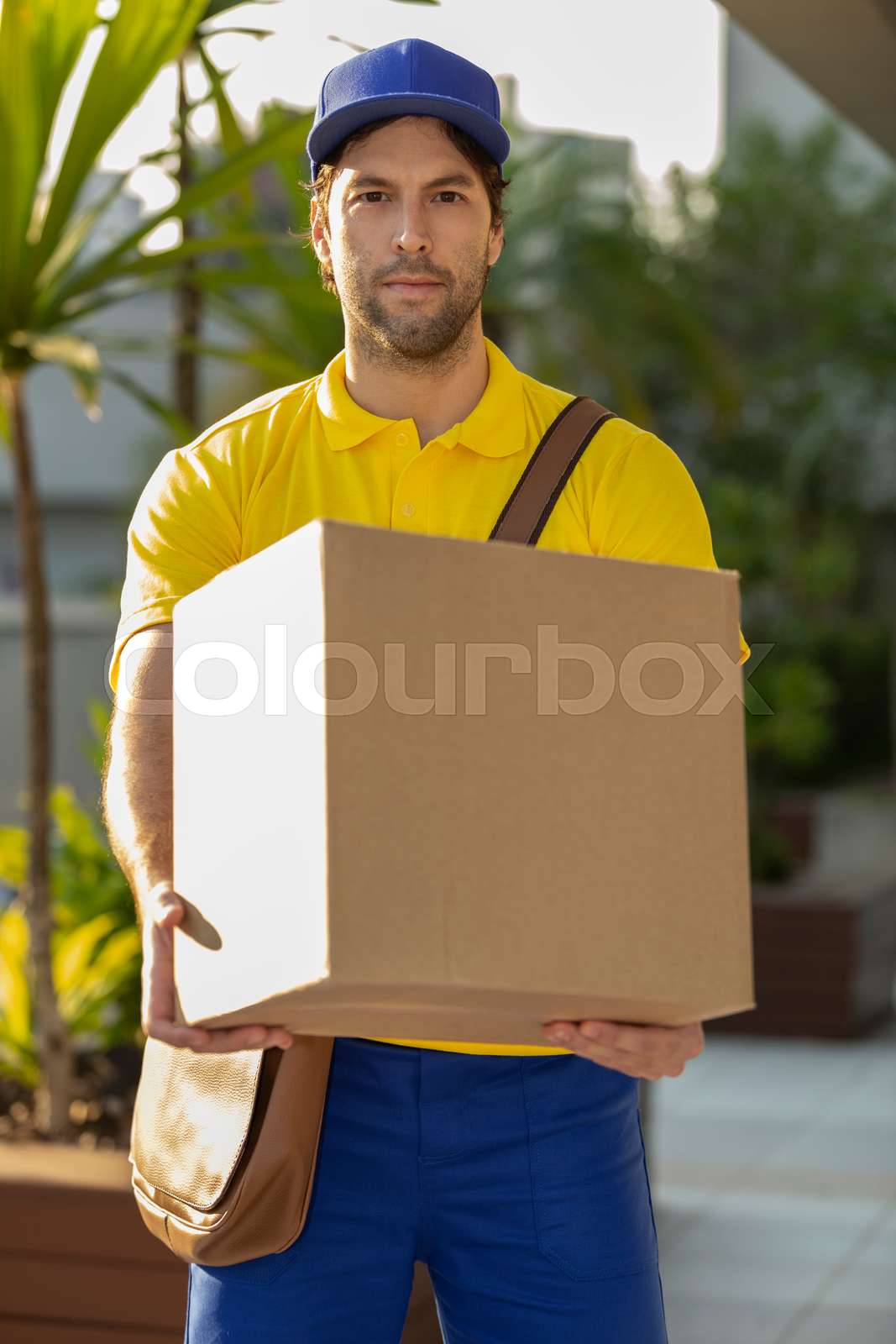 Brazilian mailman delivering a package. | Stock image | Colourbox
