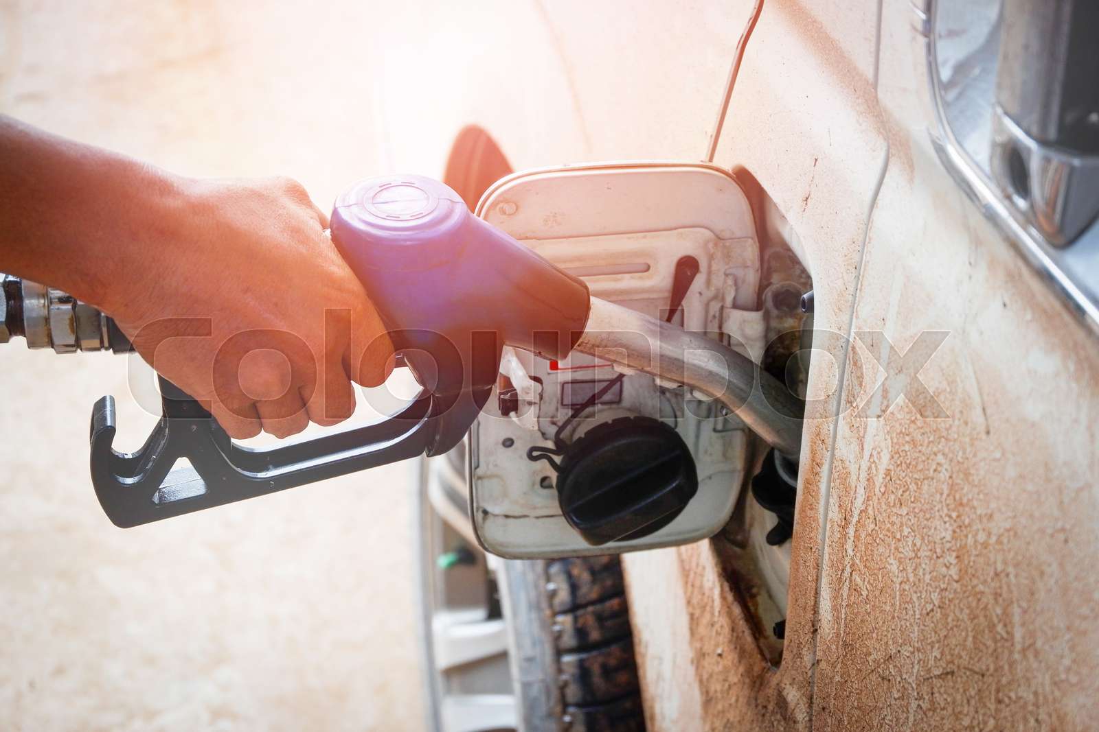 Handle fuel nozzle to refuel in gas station | Stock image | Colourbox