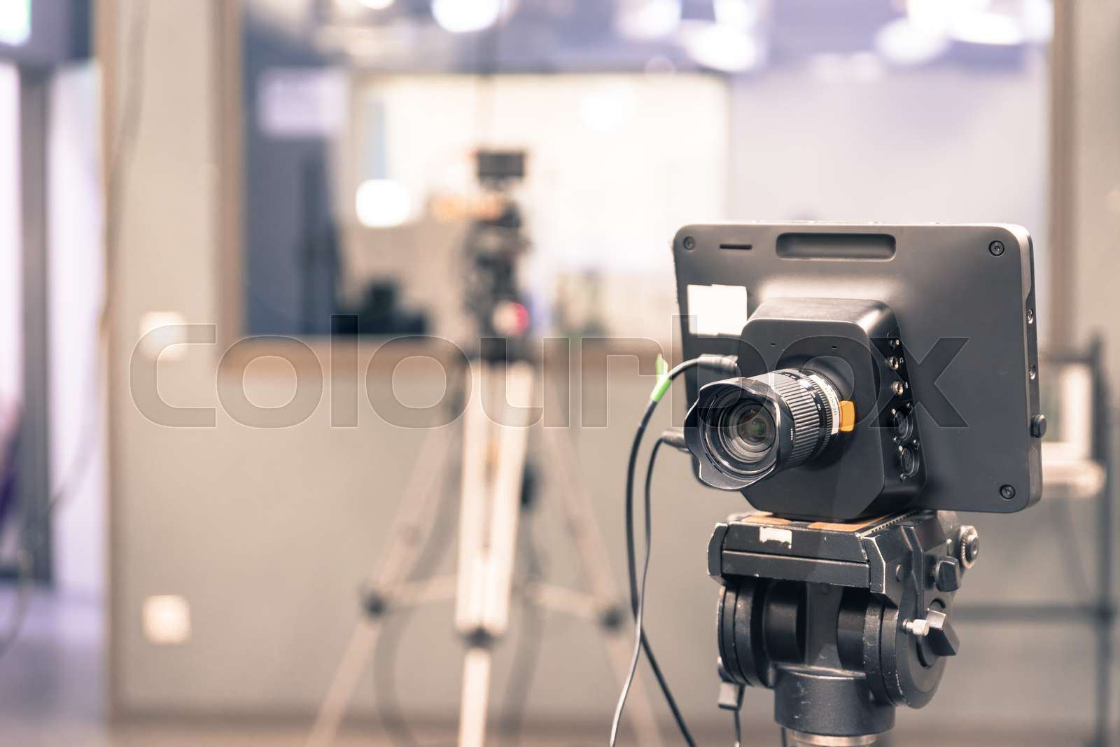 Film camera in broadcasting studio, spotlights and other equipment ...
