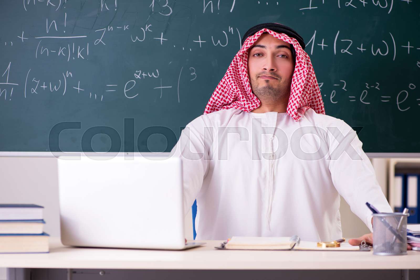 The arab teacher in front of chalkboard | Stock image | Colourbox