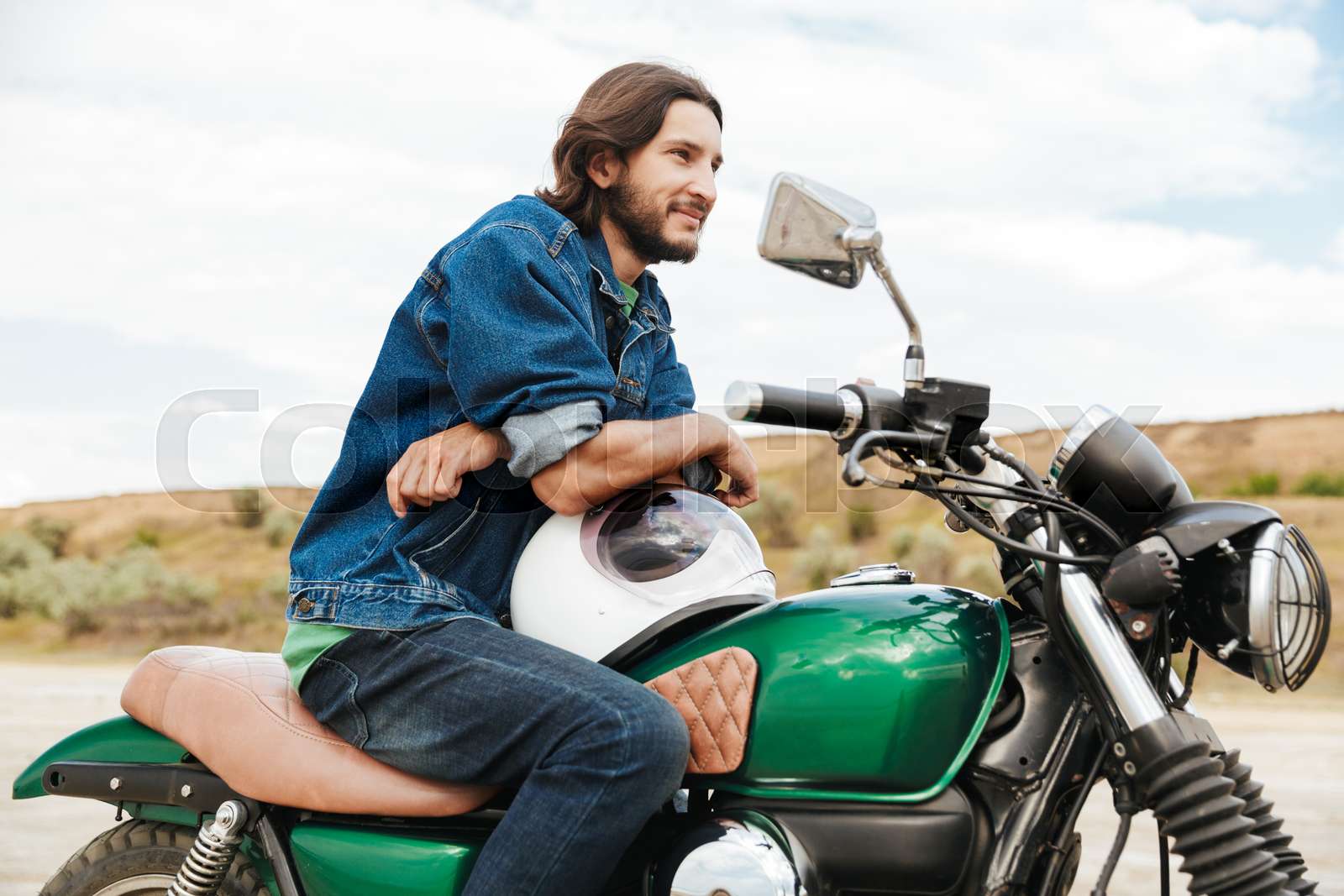 Positive optimistic happy man biker on his bike outdoors on a beach ...