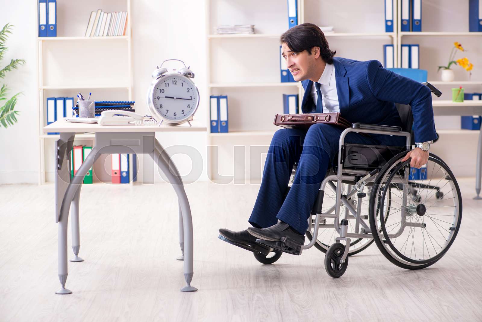 Young male employee in wheelchair working in the office | Stock image ...