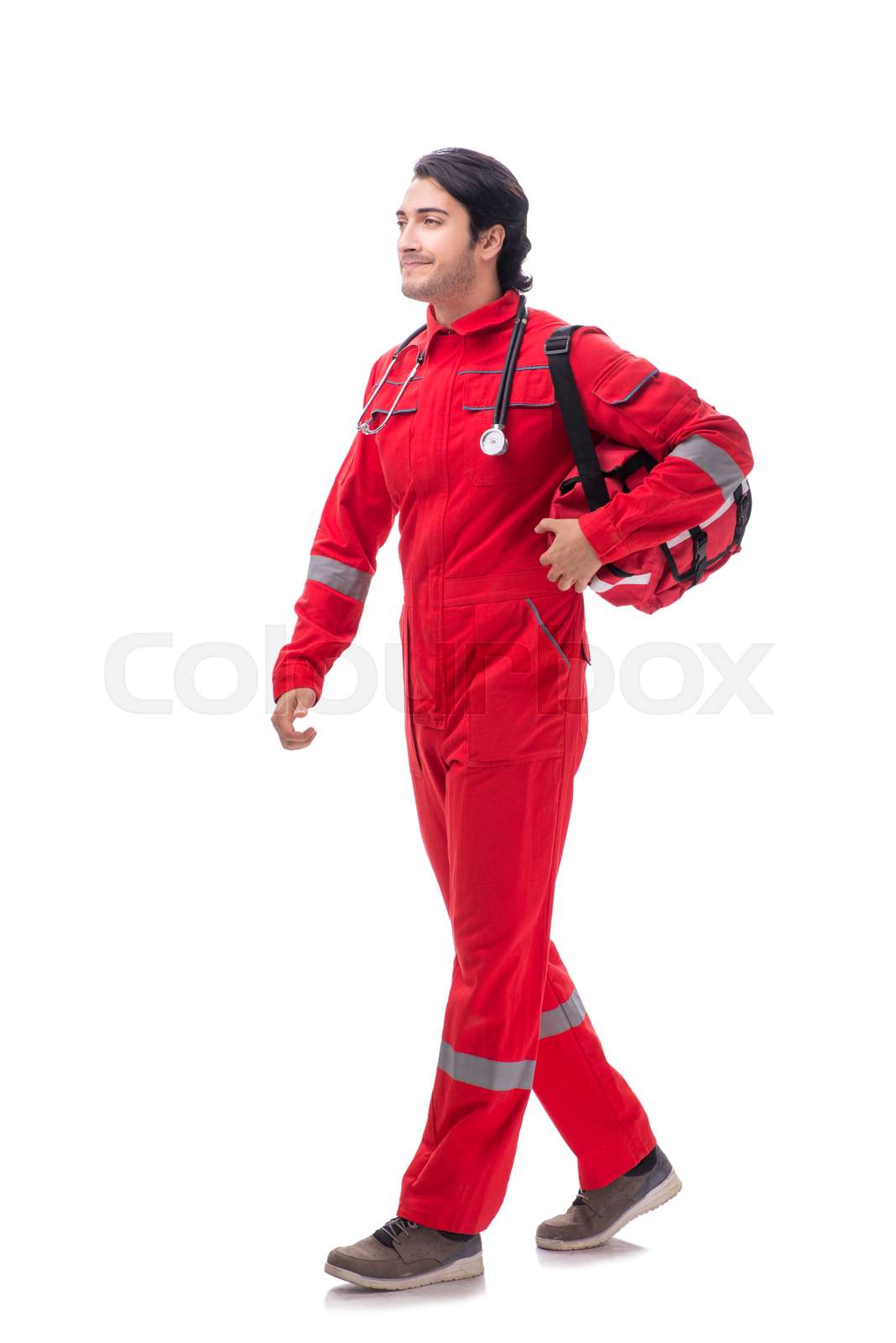Young paramedic in red uniform isolated on white | Stock image | Colourbox
