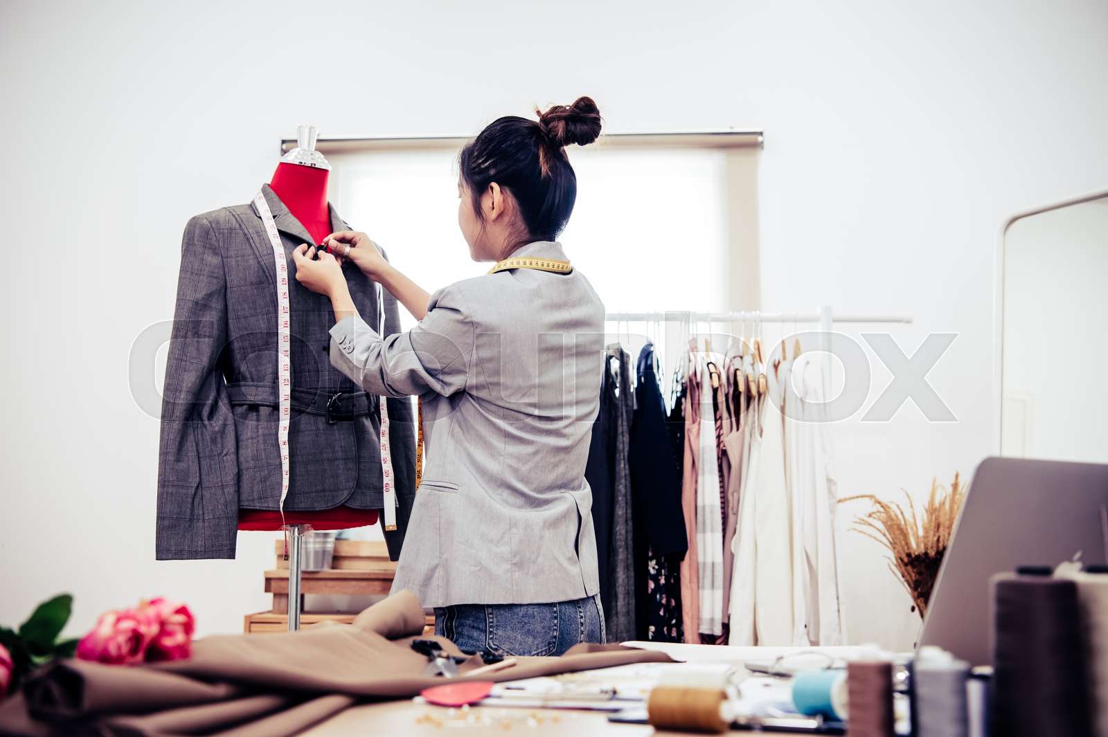Asian female fashion designer girl making fit on the formal suit ...
