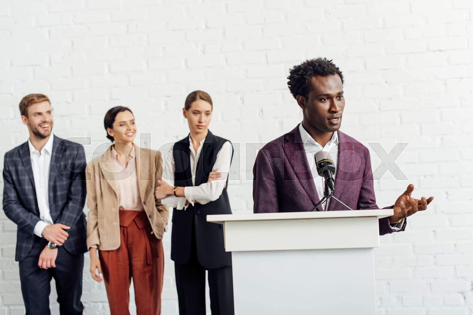 african american businessman in formal wear talking during conference ...