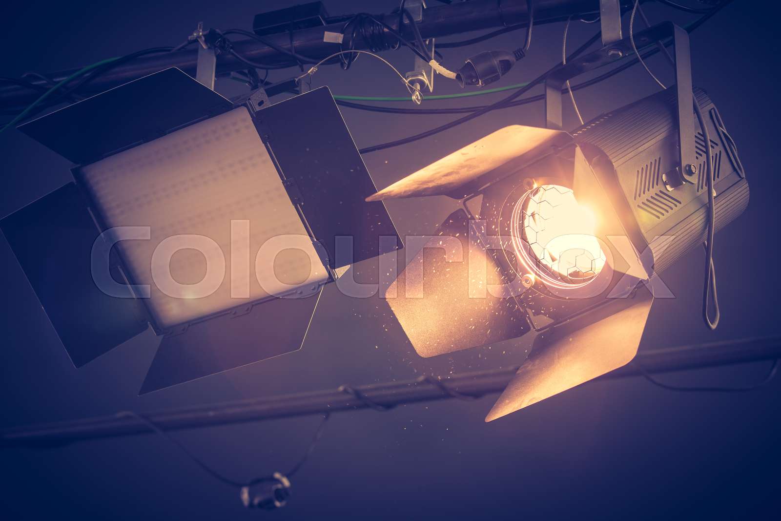 Professional orange studio spotlight in a TV studio. Lighted dust ...