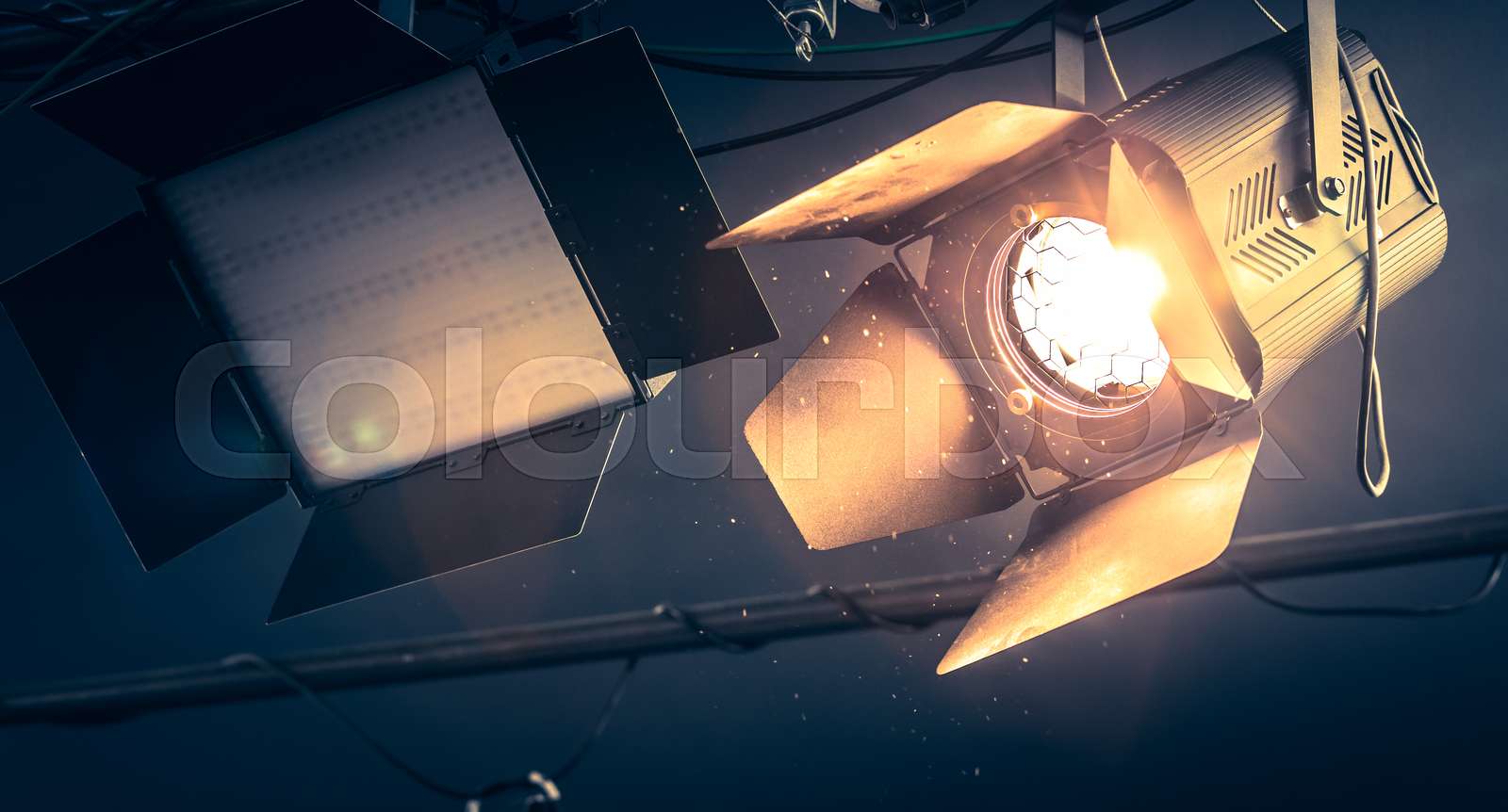 Professional orange studio spotlight in a TV studio. Lighted dust ...