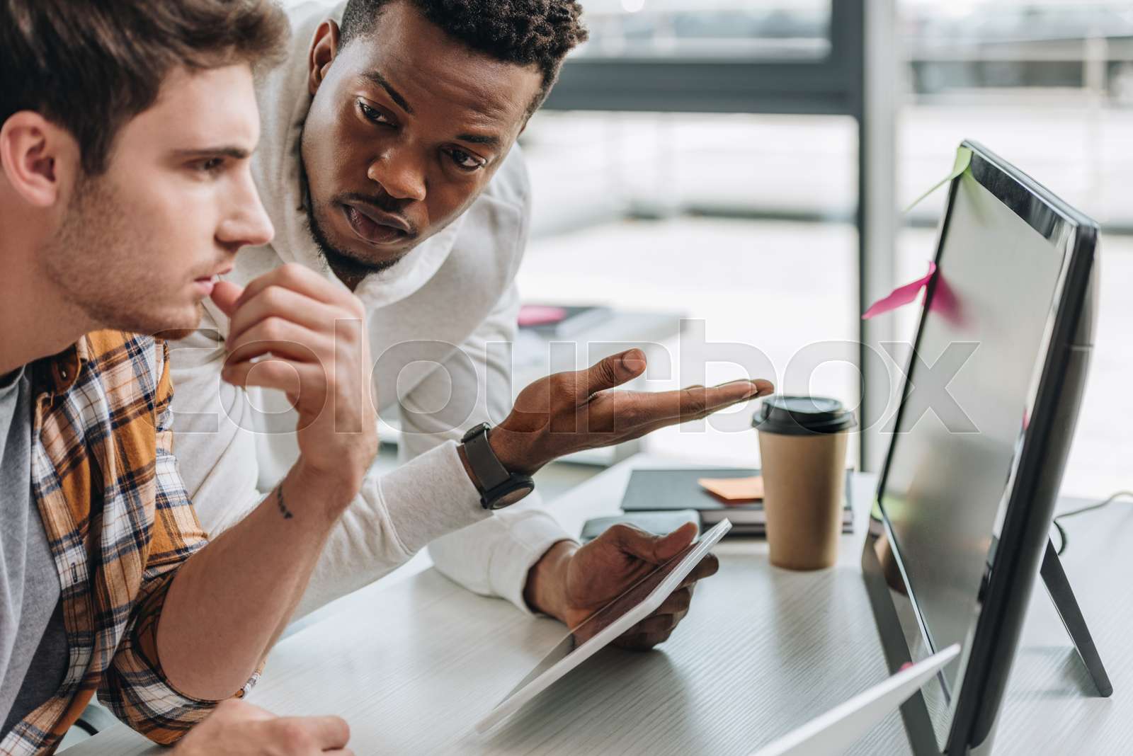 serious african american programmer pointing at computer monitor near colleague | Stock image ...