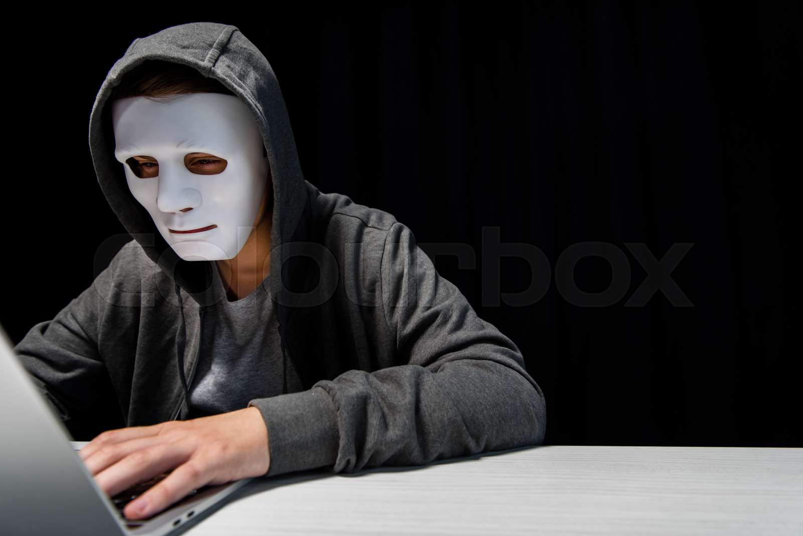 anonymous internet troll in mask typing on laptop keyboard isolated on ...