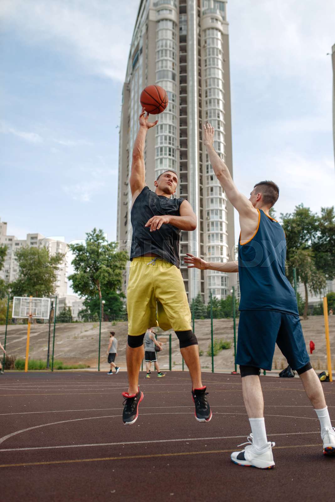 Two basketball players playing on outdoor court | Stock image | Colourbox
