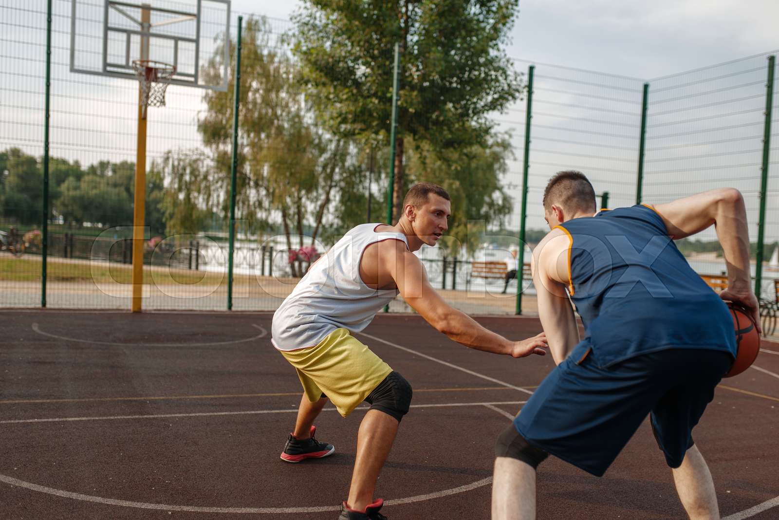 Basketball players playing intense match outdoor | Stock image | Colourbox