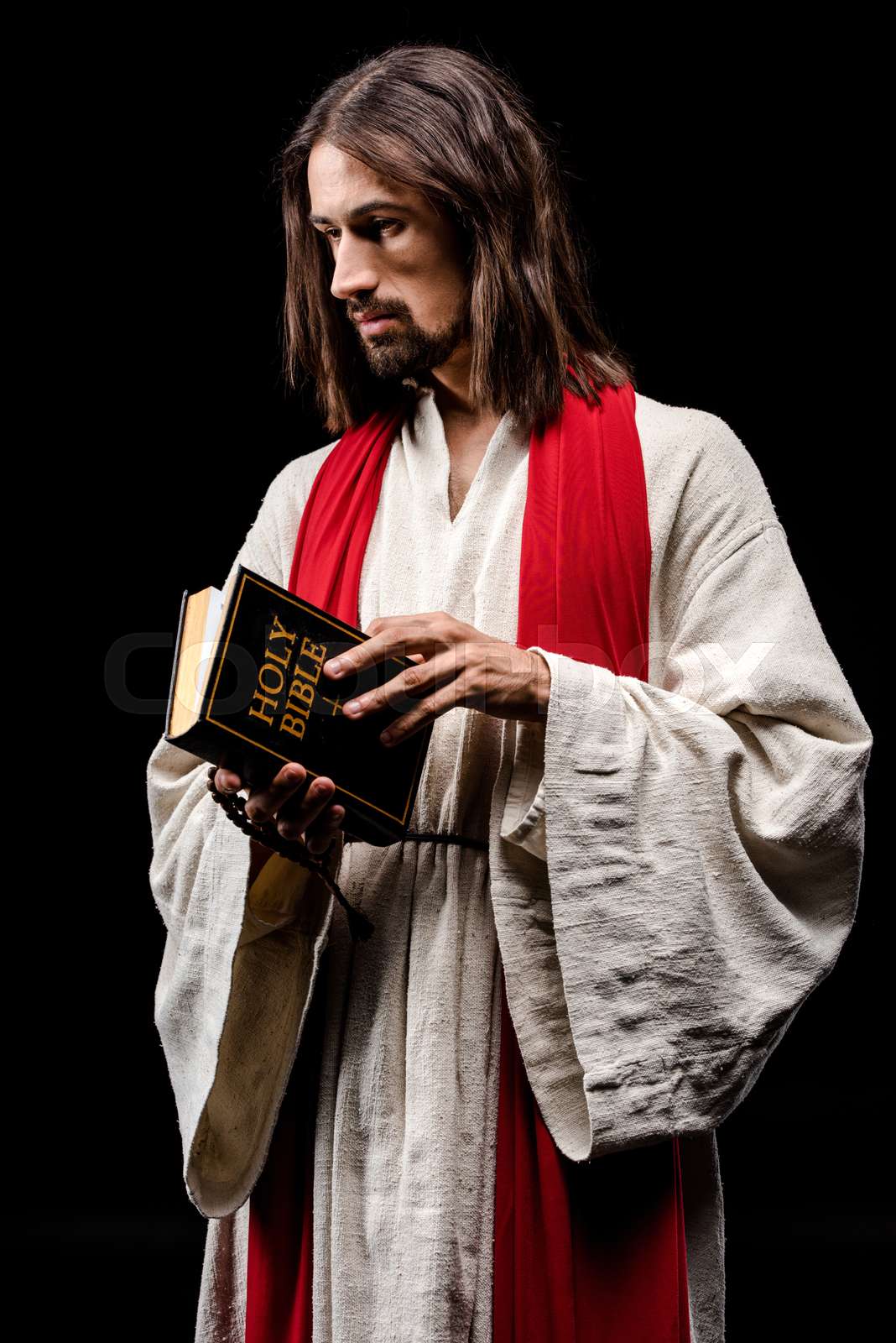 handsome man holding holy bible isolated on black | Stock image | Colourbox