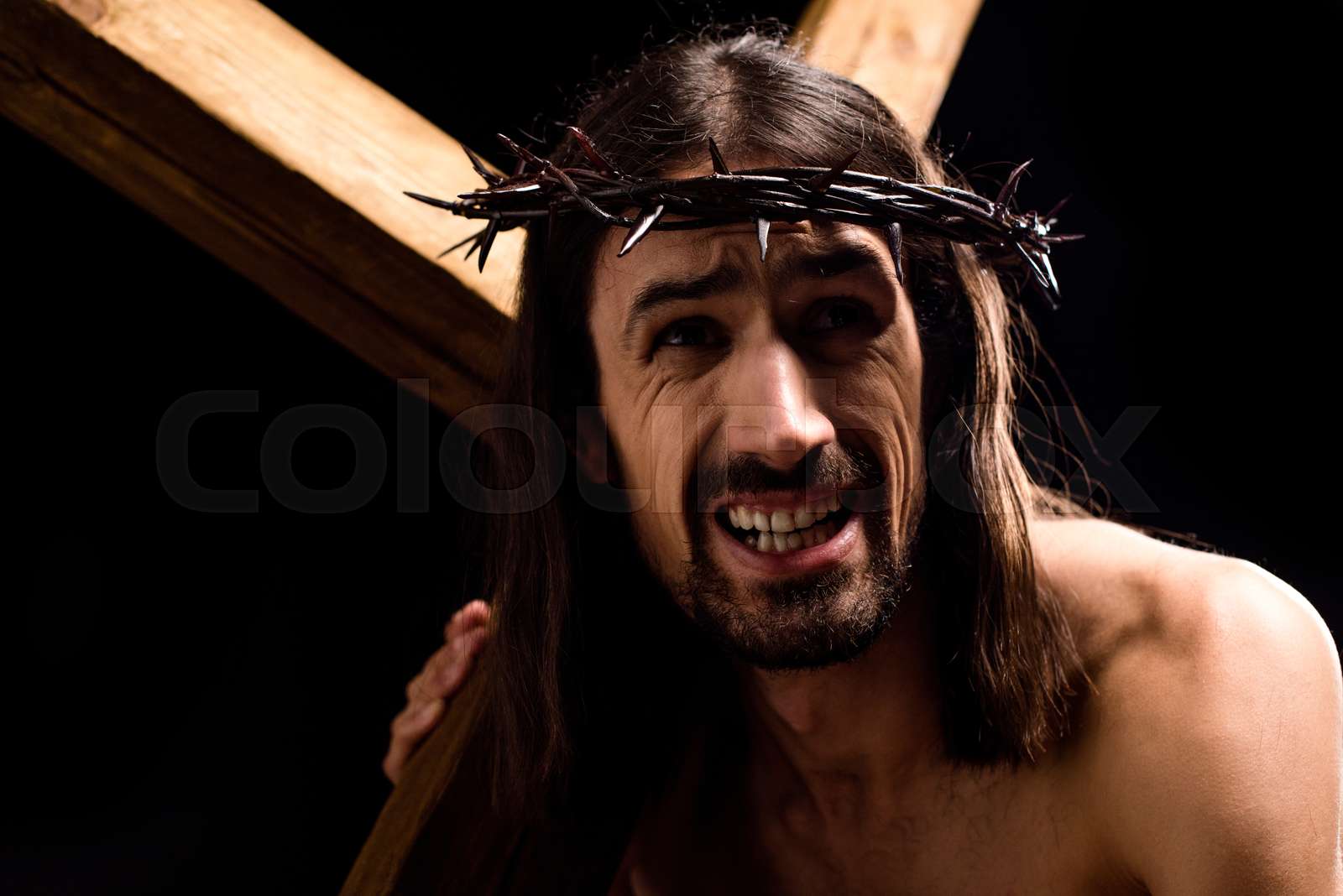 jesus holding heavy wooden cross isolated on black | Stock image ...