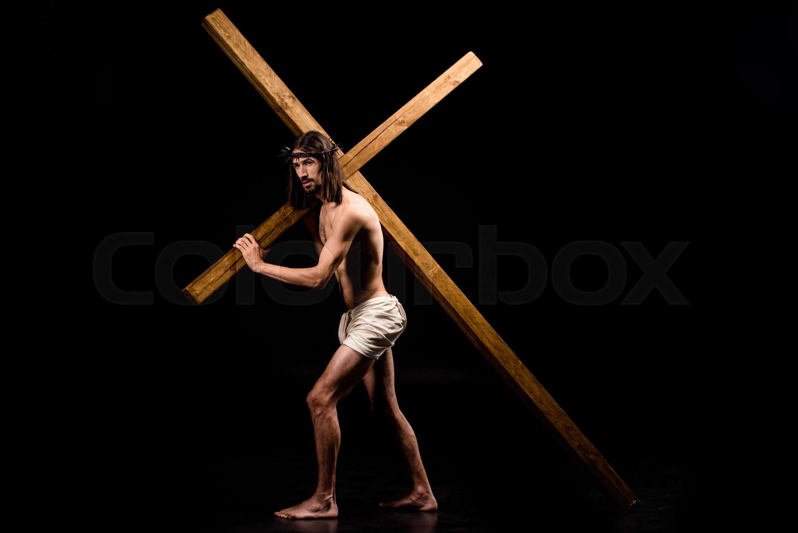 shirtless jesus in wreath holding wooden cross and standing on black ...