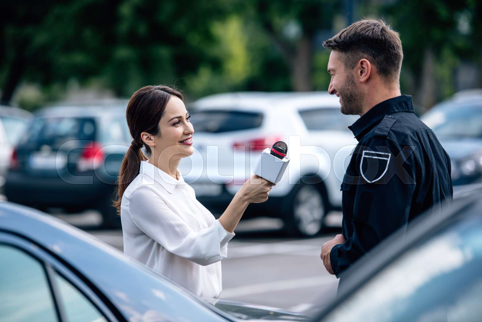 journalist holding microphone and talking with handsome policeman in ...