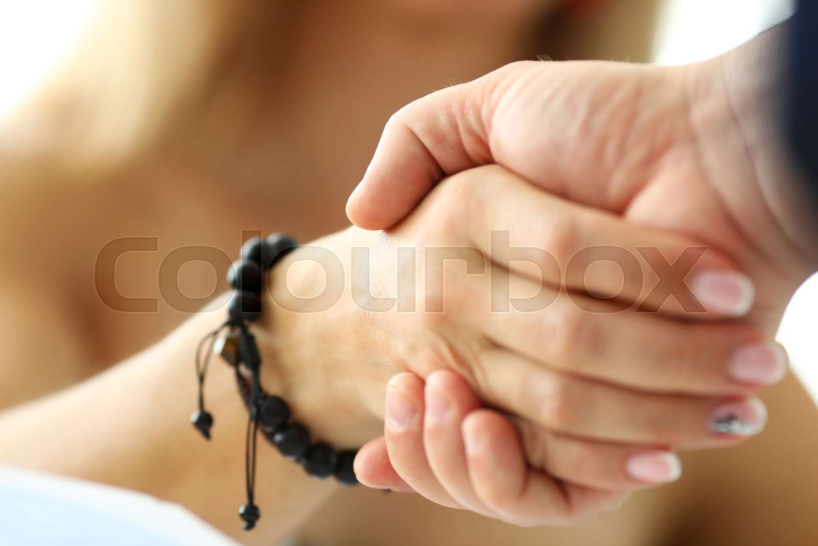 Man and woman shaking arms as successful bargain | Stock image | Colourbox