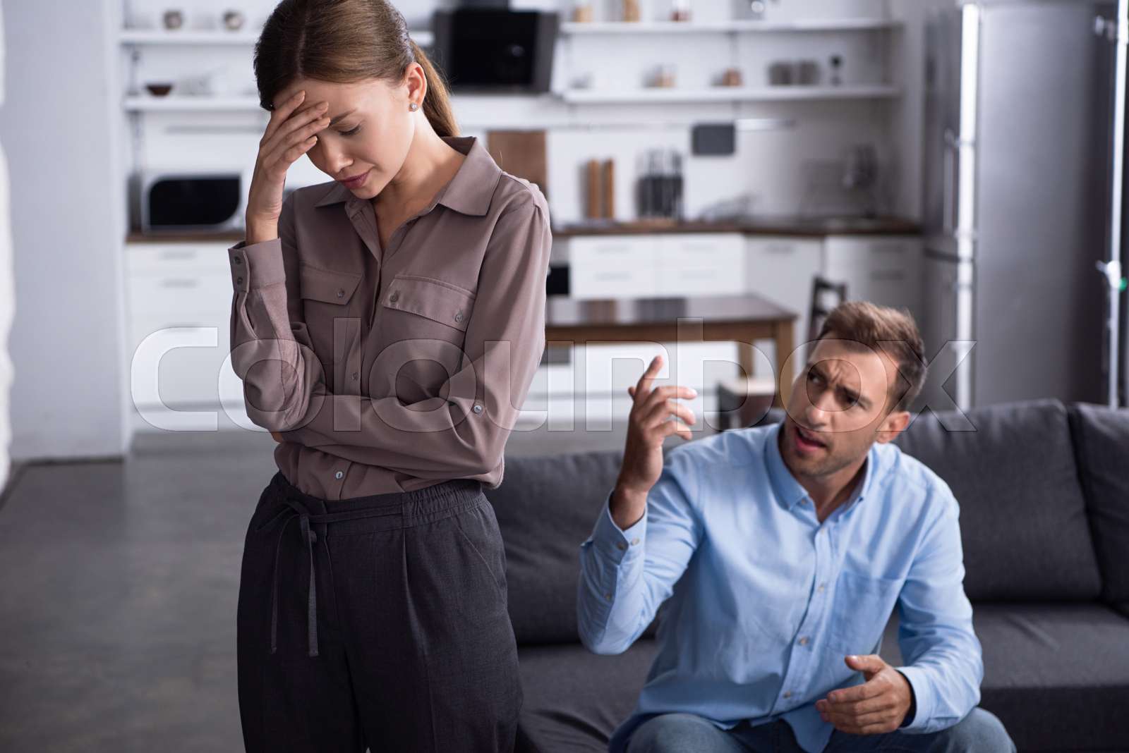 sad tired woman and angry man sitting on sofa at home | Stock image ...