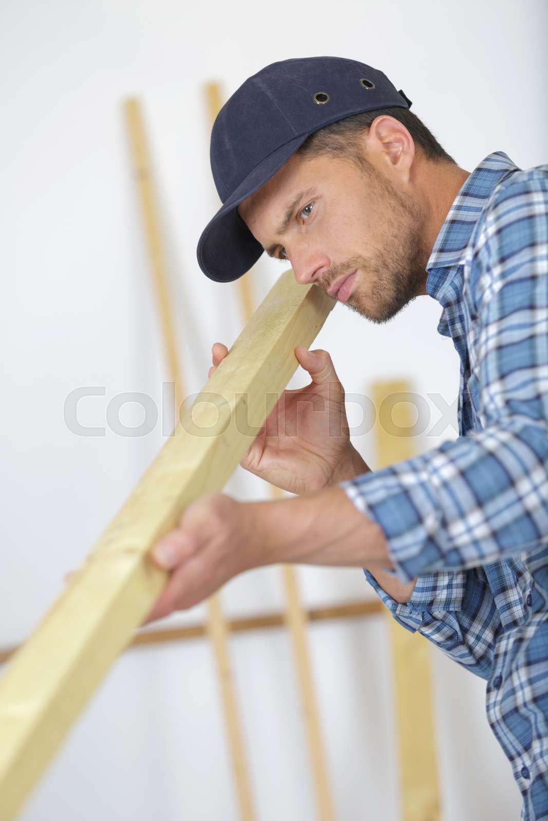 carpenter checking wood is straight | Stock image | Colourbox