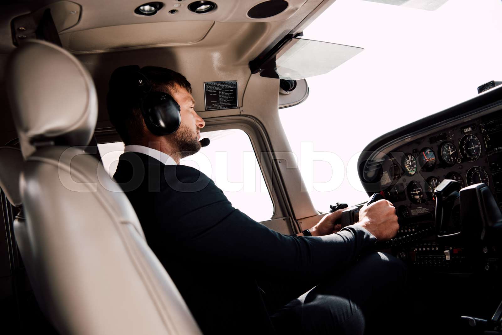 pilot in formal wear sitting in plane and holding | Stock image | Colourbox
