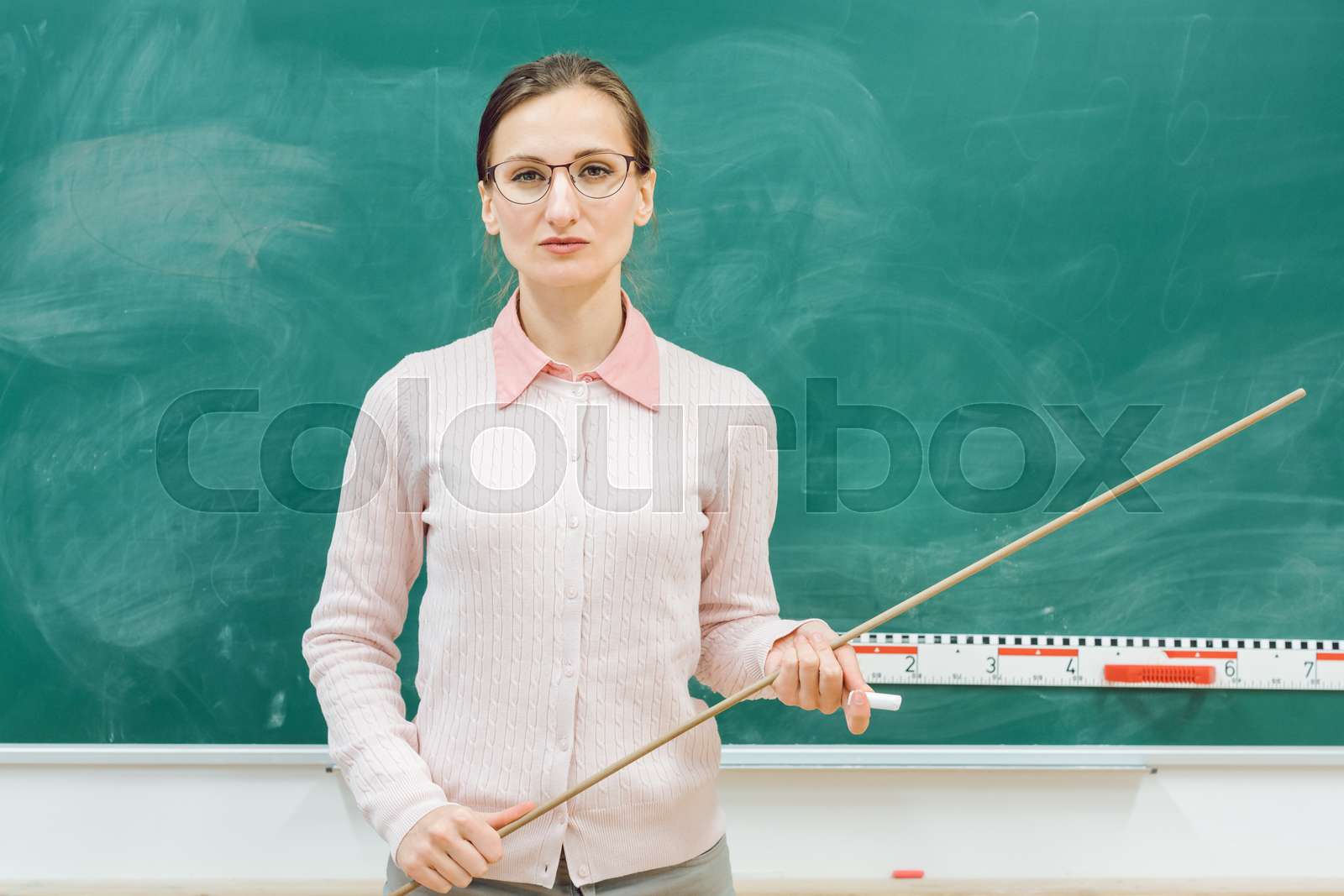 strict teacher standing in front of blackboard in class | Stock image ...