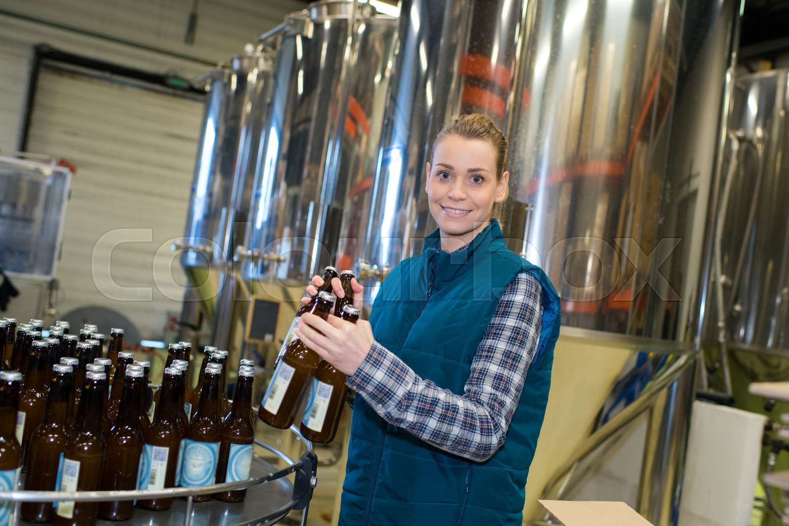 portrait of joyful smiling worker working on beer brewery factory ...