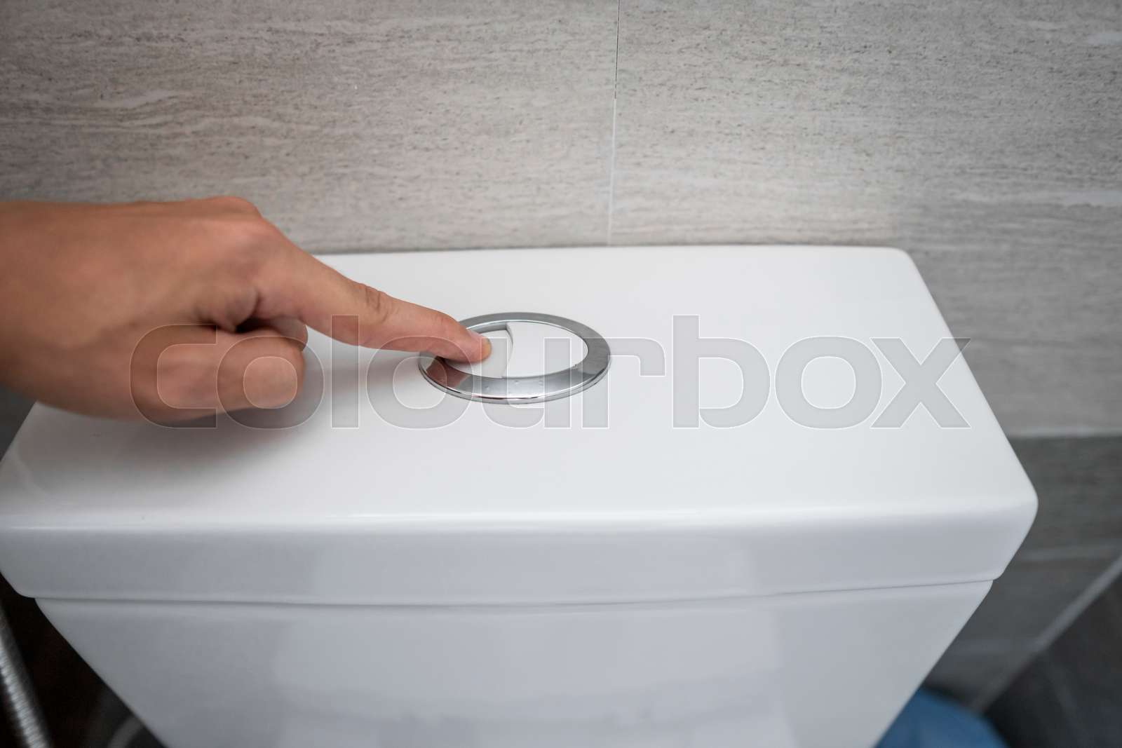 Close up of finger pushing a flush toilet button for cleaning a toilet ...