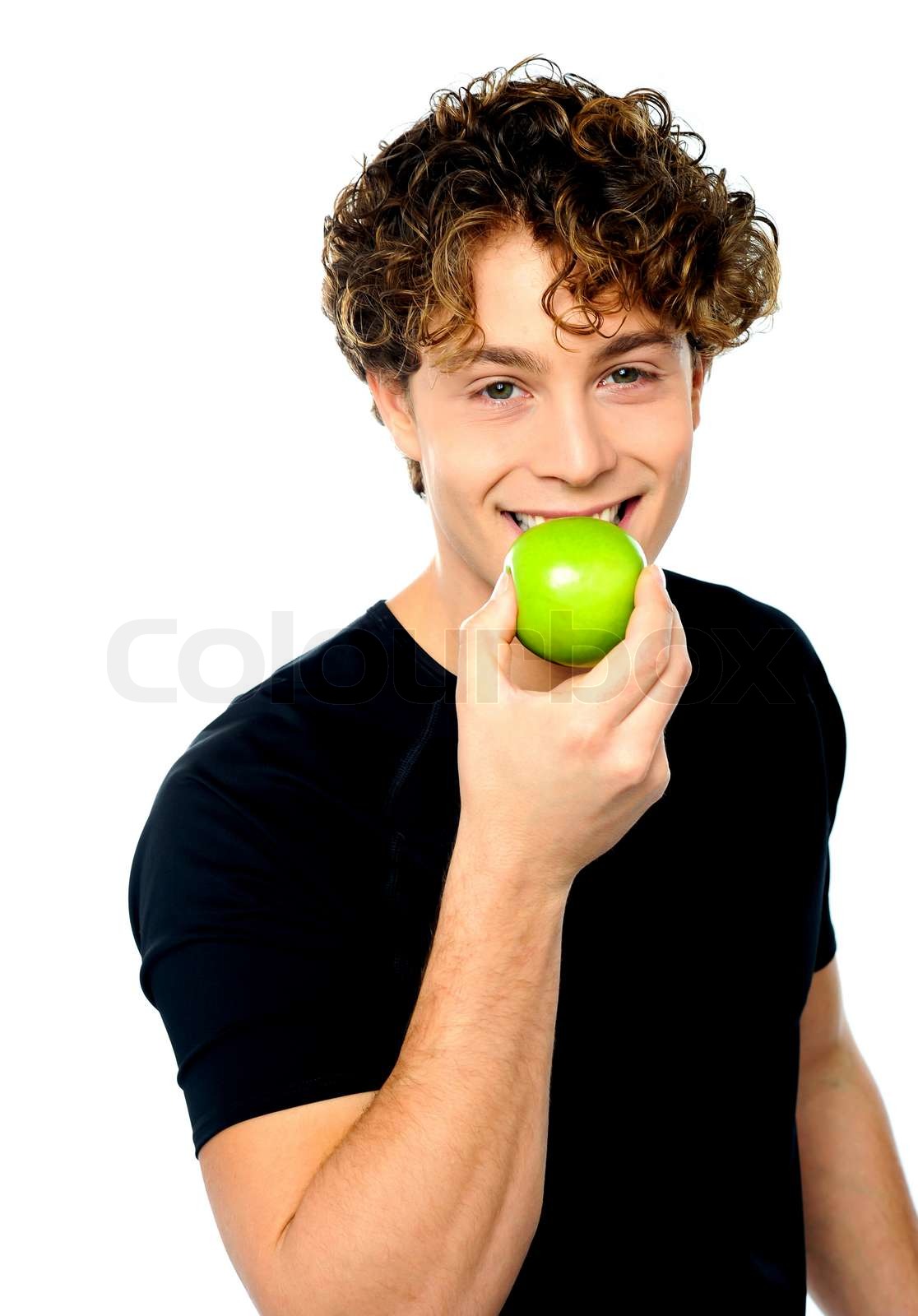 Young man eating fresh healthy green apple | Stock image | Colourbox