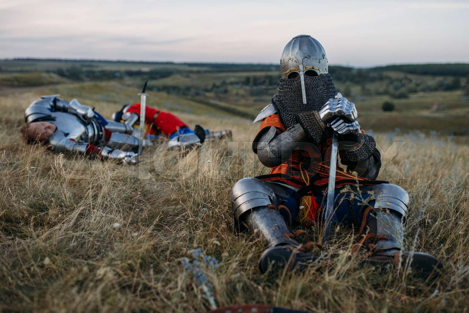 Medieval knight in armor sitting on the ground | Stock image | Colourbox