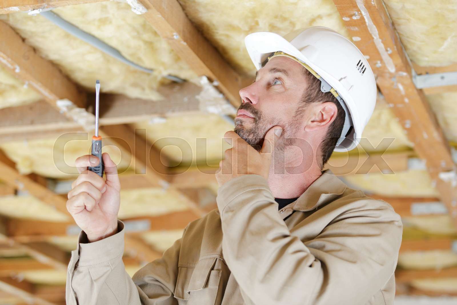 worker is fixing something in the ceiling | Stock image | Colourbox