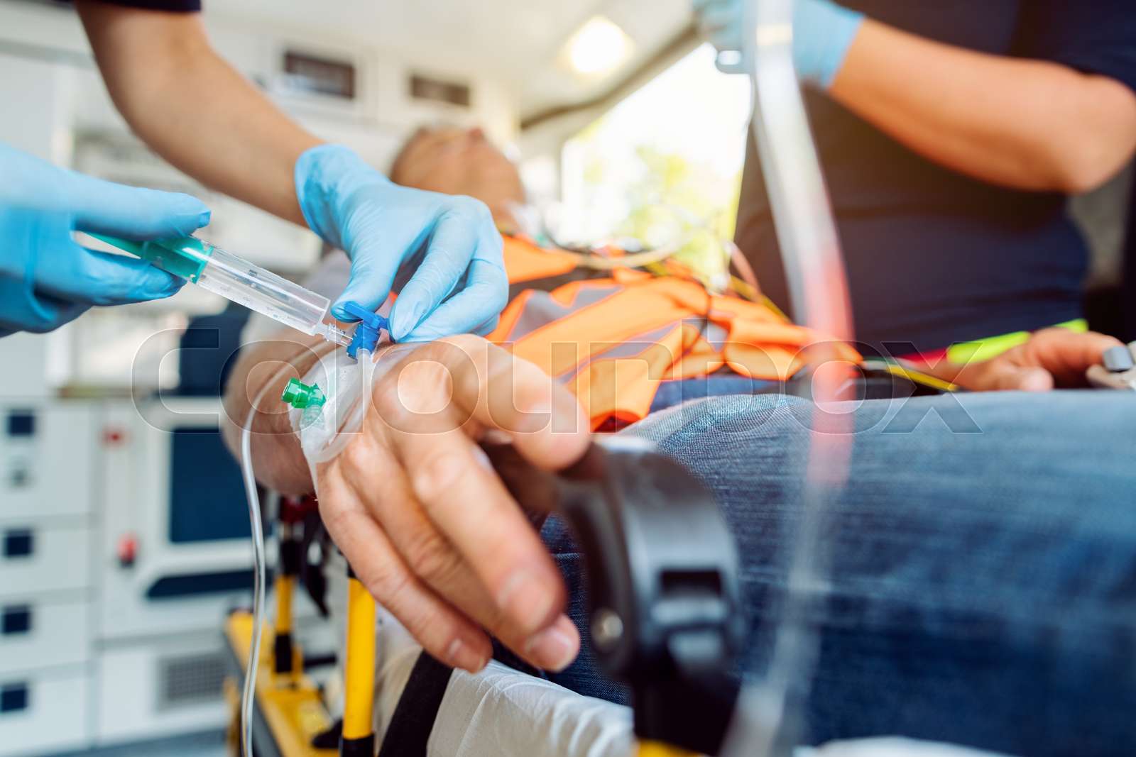 Emergency doctor administering injection needle in ambulance | Stock ...