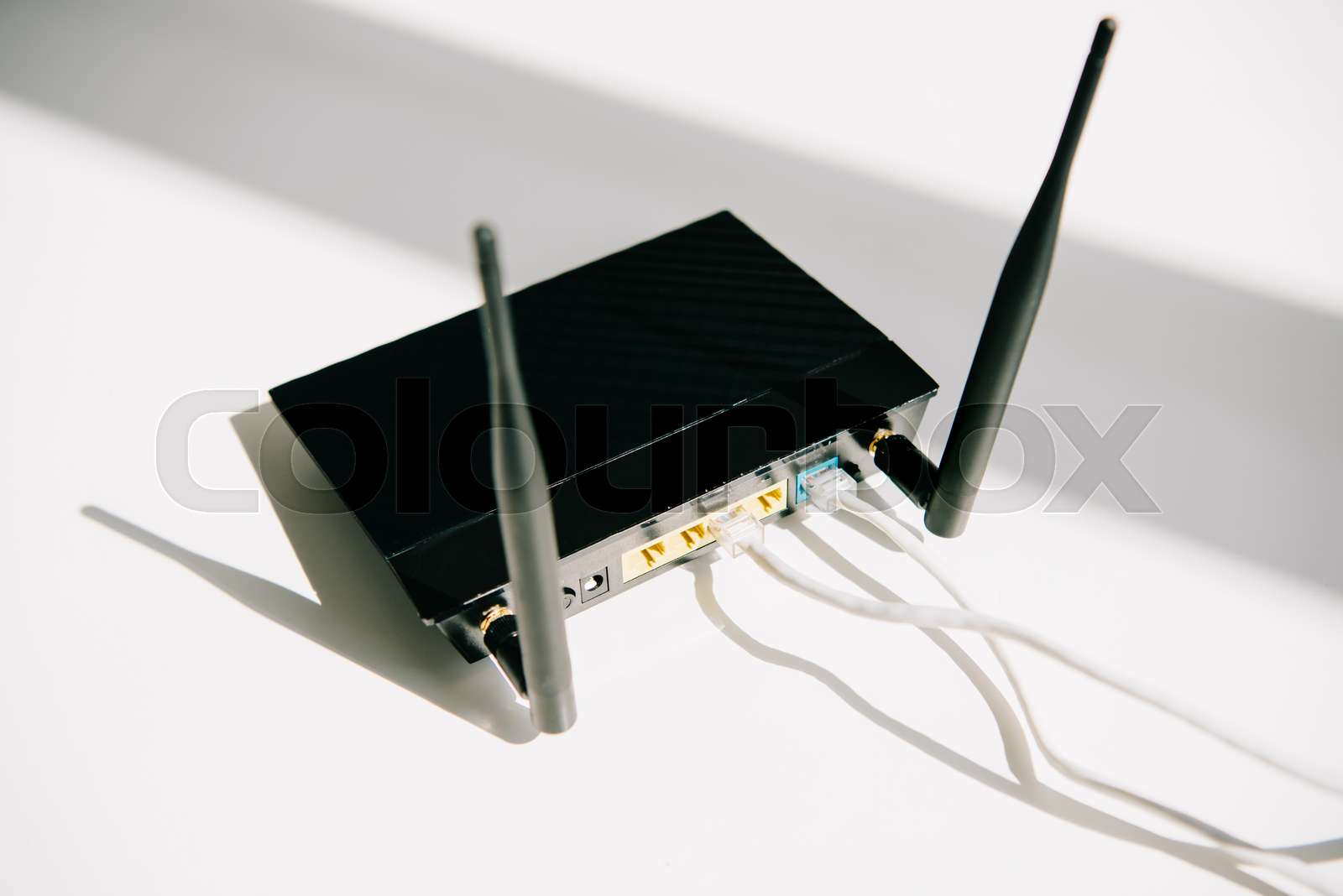 black plugged router on white office table in sunshine | Stock image ...