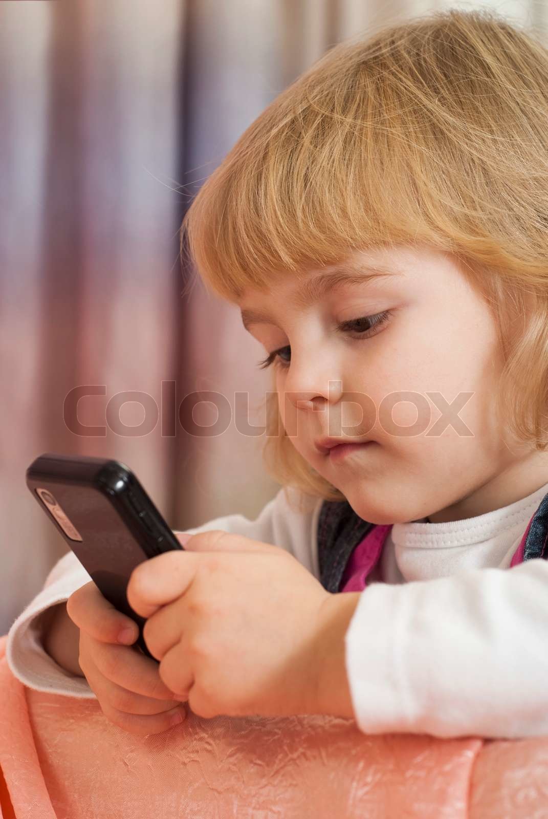 Beautiful little girl with a phone in their hands | Stock image | Colourbox