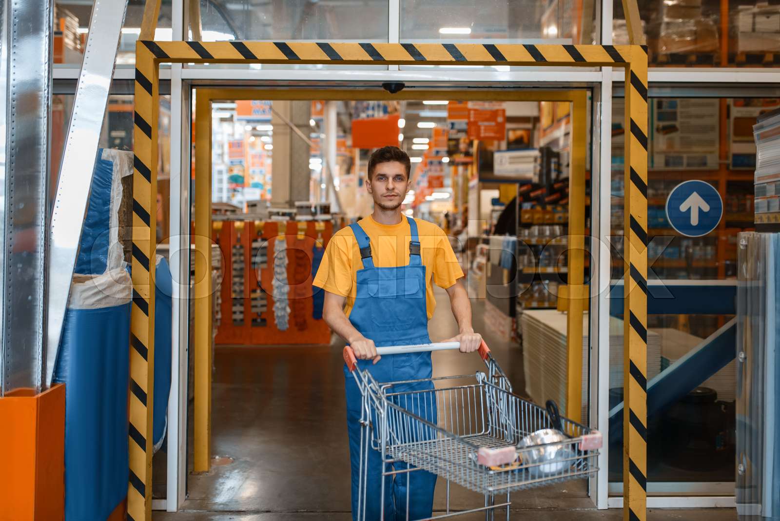 Male builder carries building materials in a cart | Stock image | Colourbox