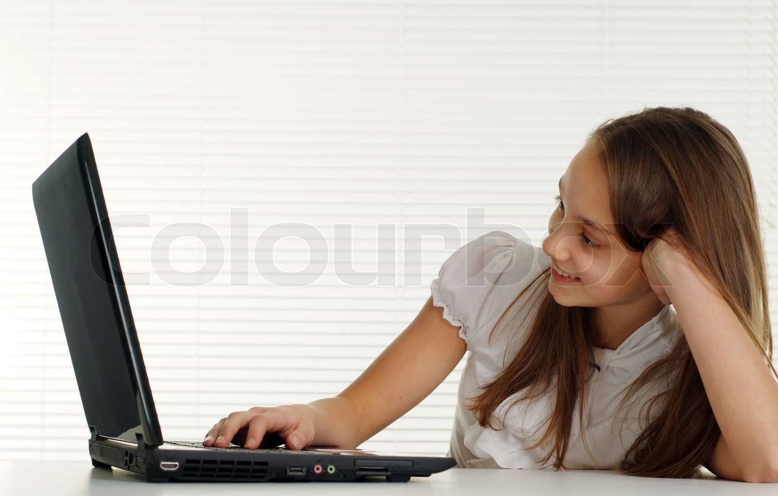 Das Mädchen am Computer sitzt | Stock Bild | Colourbox