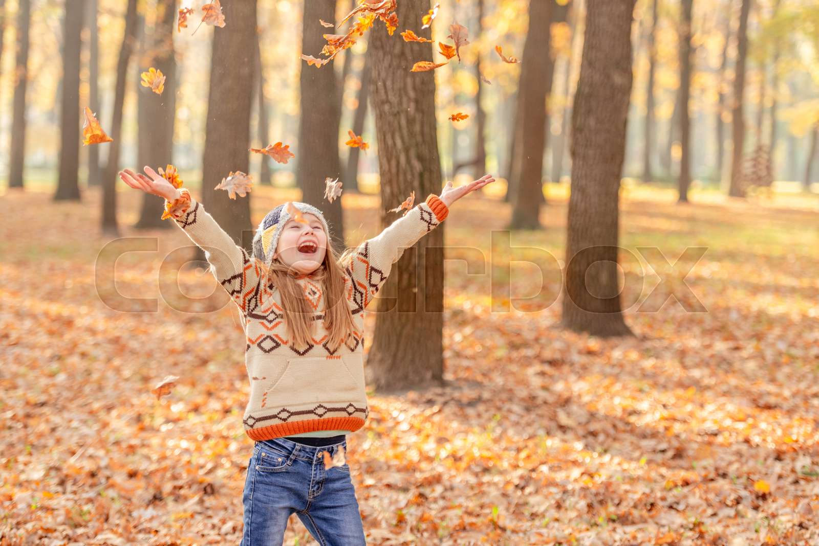 Little girl throwing up leaves | Stock image | Colourbox