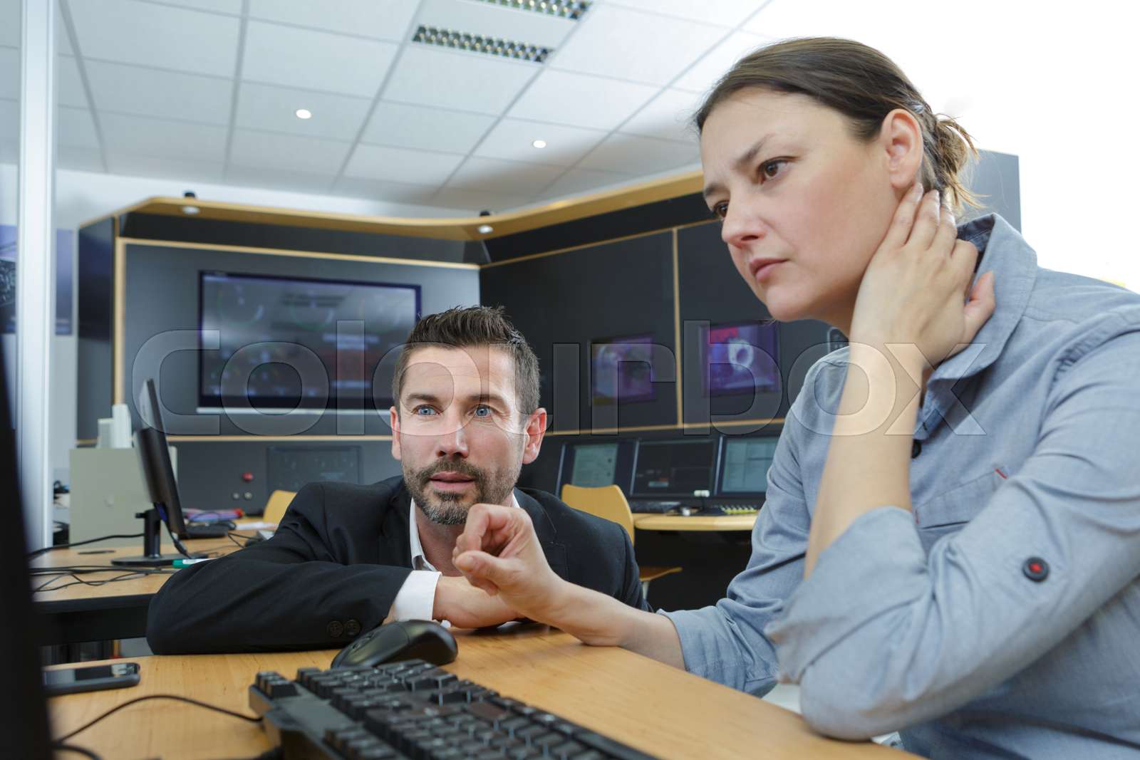 workers looking seriously at monitors in control center | Stock image ...