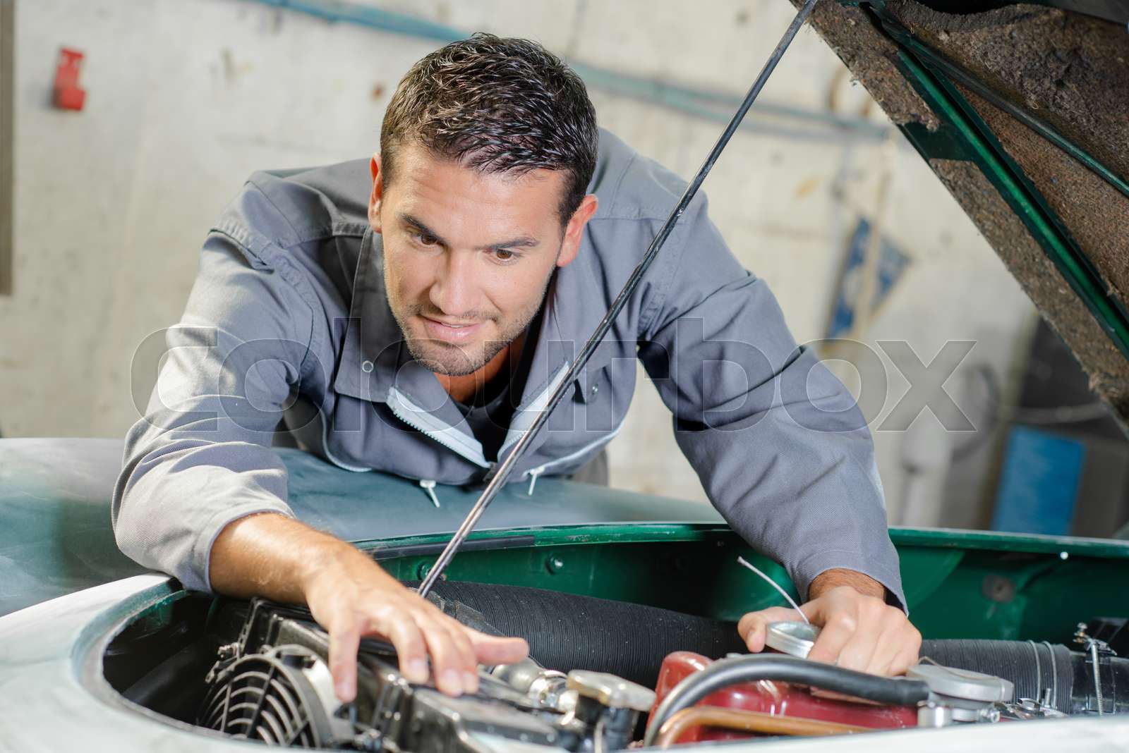 mechanic working in engine bay | Stock image | Colourbox