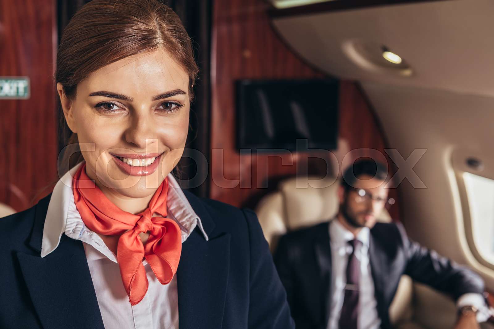 selective focus of smiling and attractive flight attendant looking at ...