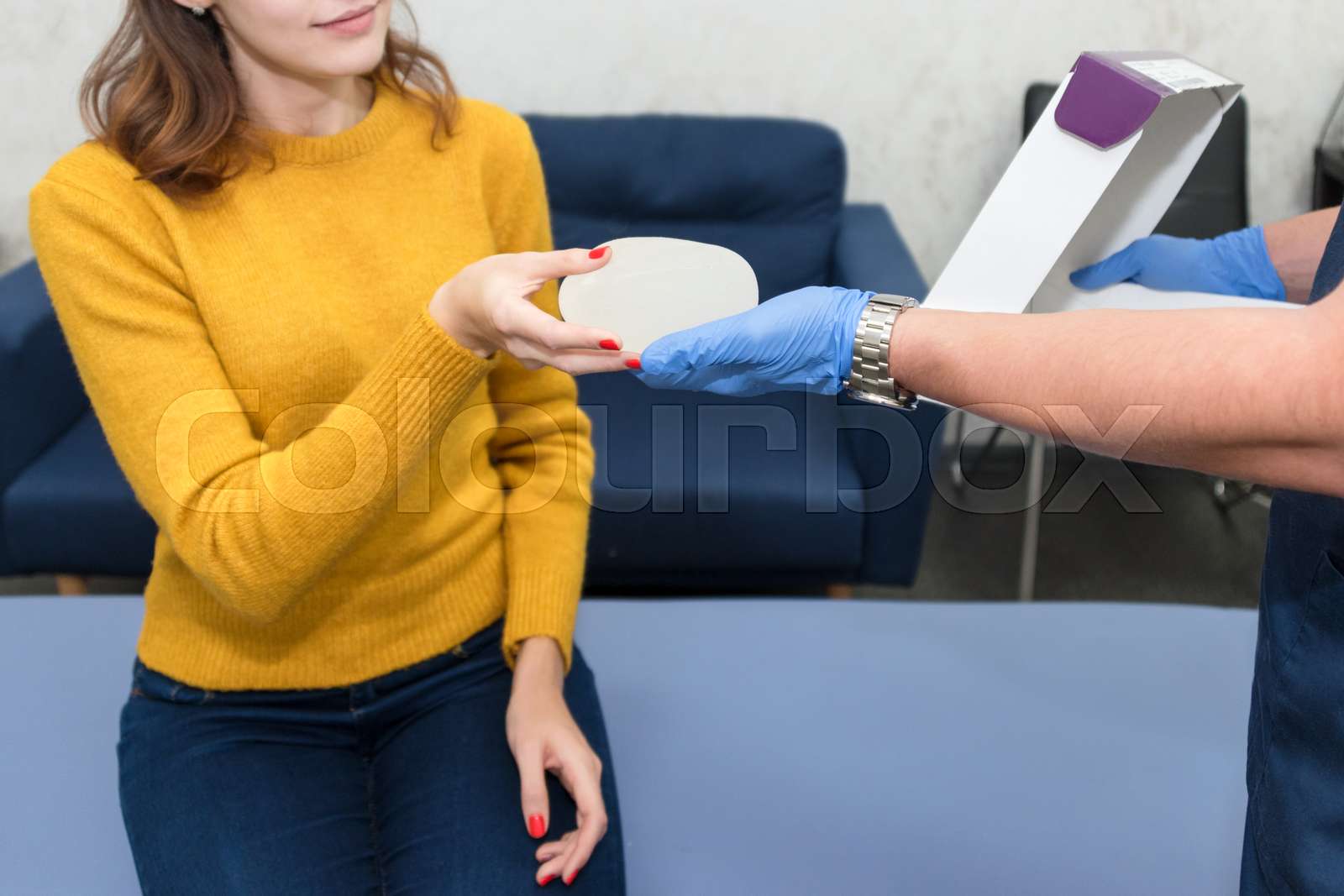 Woman planning to have a breast implant. Doctor showing breasts ...