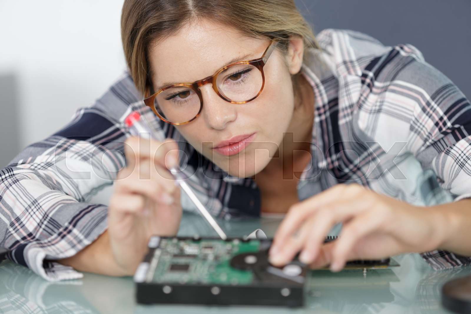 woman soldering elements of circuit board | Stock image | Colourbox