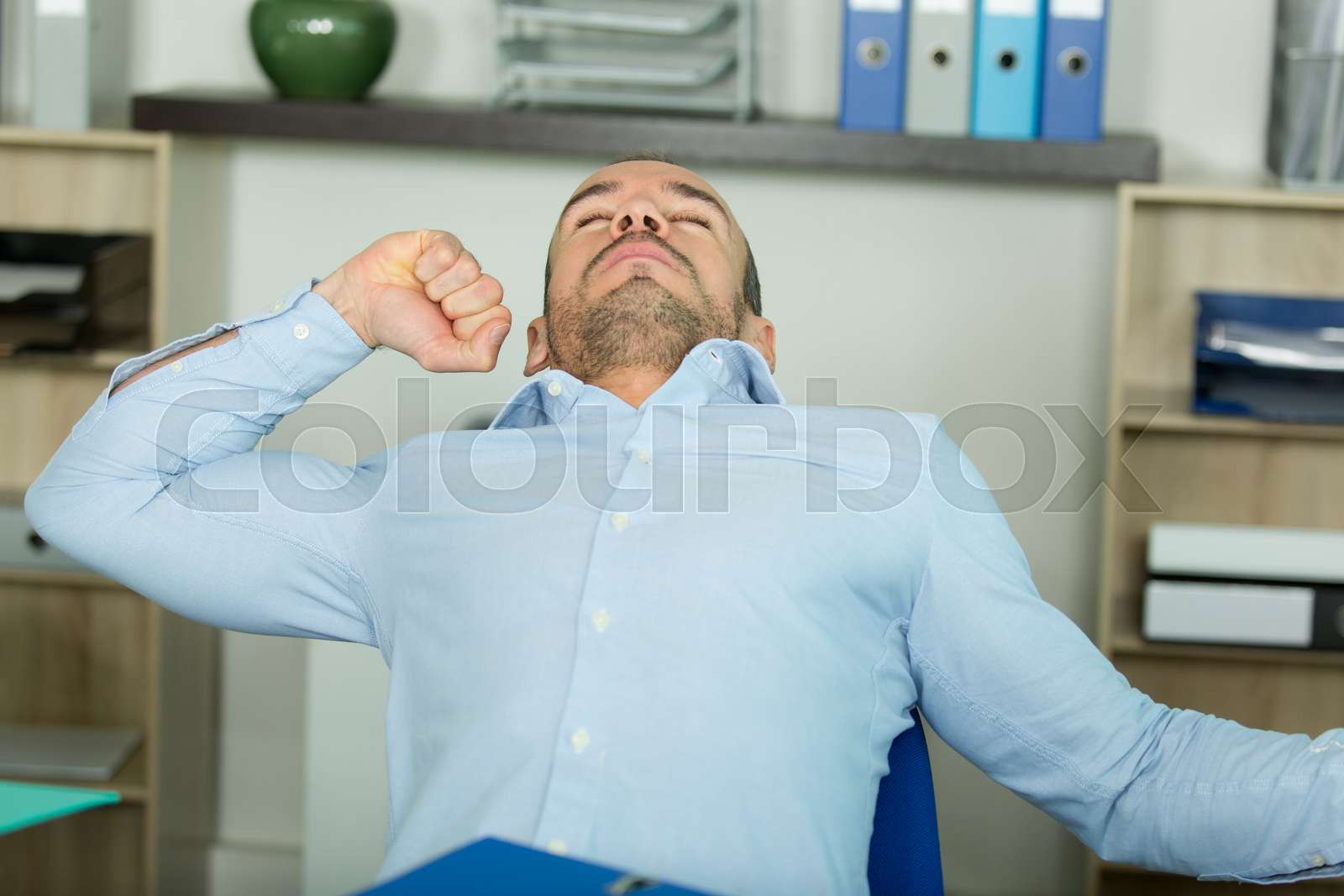 male office worker stretching his back | Stock image | Colourbox