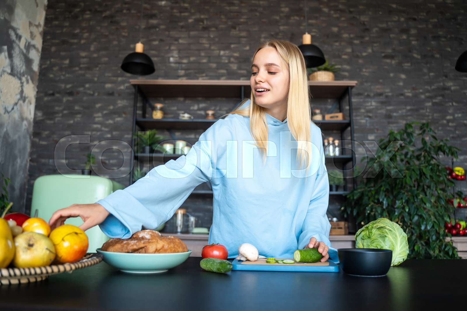 Beautiful young girl posing in the kitchen | Stock image | Colourbox