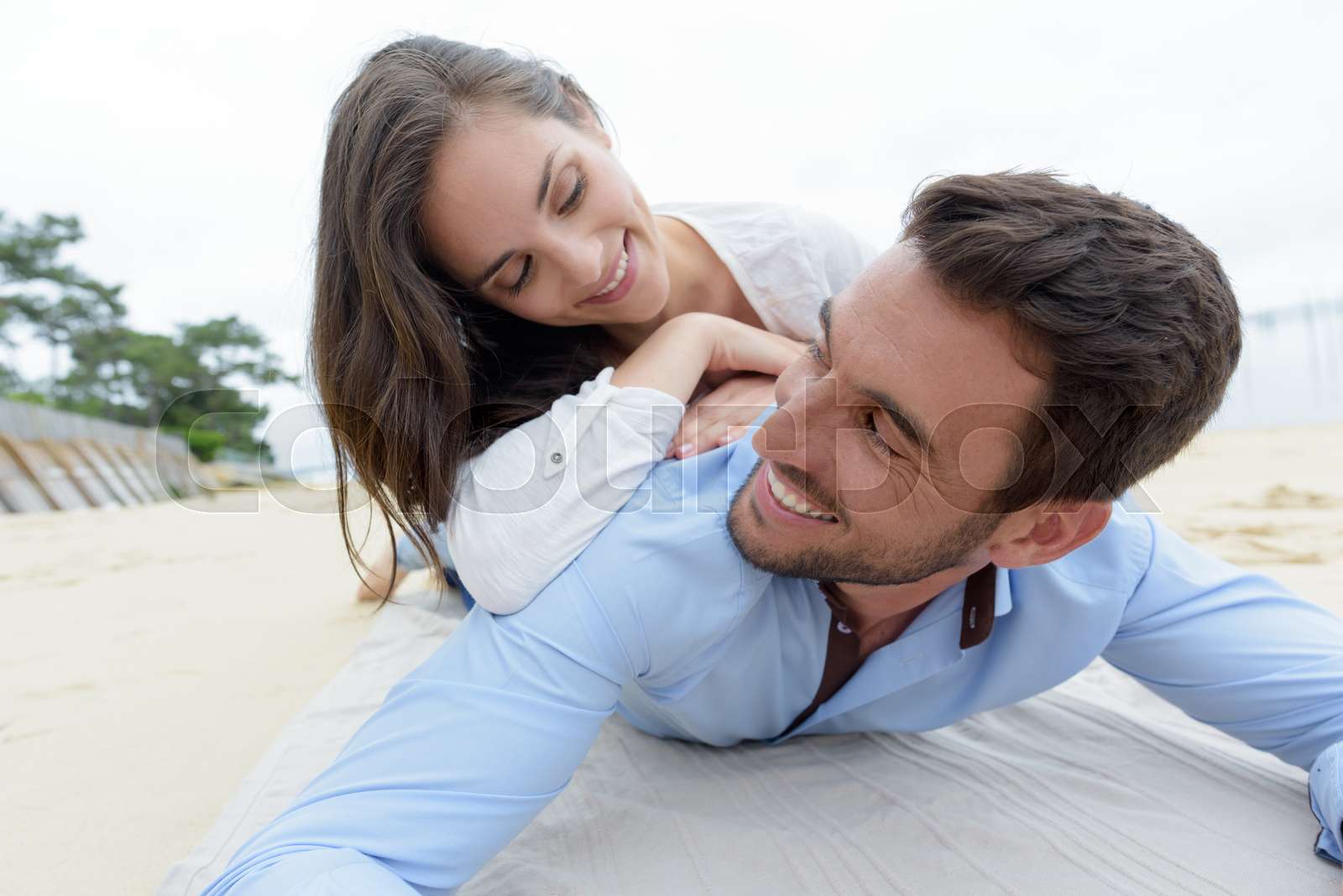 woman layed on partners back on the beach | Stock image | Colourbox