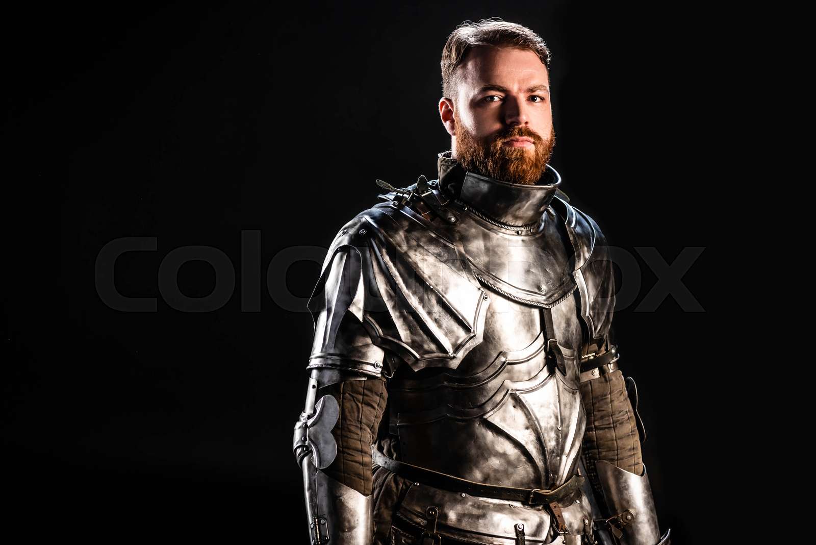 handsome knight in armor looking at camera isolated on black | Stock ...